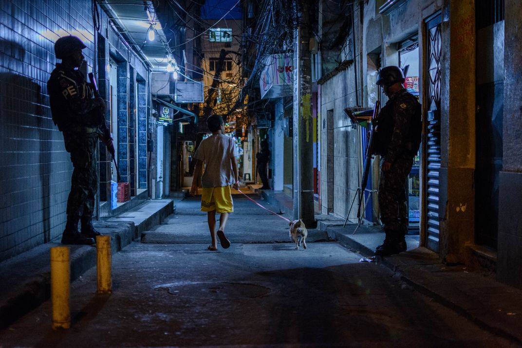Boy walks dog during occupation of Rocinha Favela by military ...