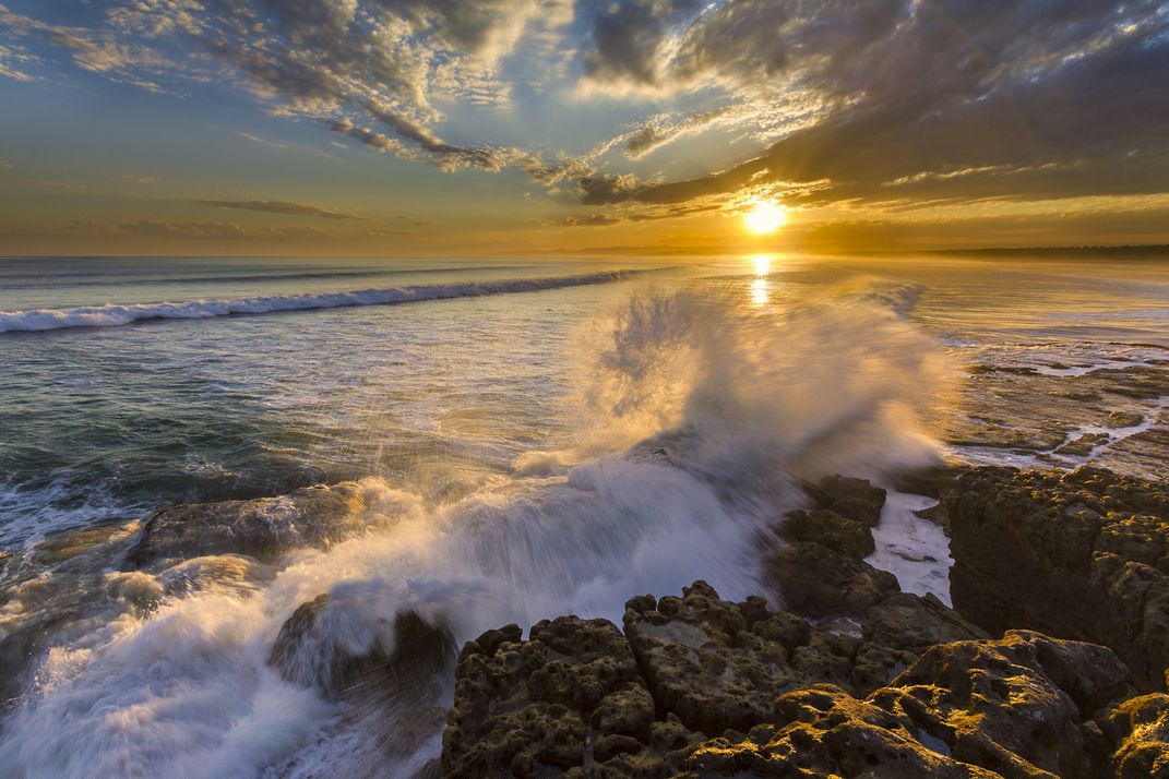 A wave breaks on rocks at the eastern end of Bherwerre Beach in the ...