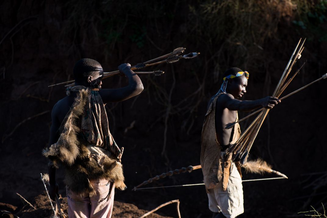 Hazabe hunters making their way into a dry river bed on a morning hunt ...