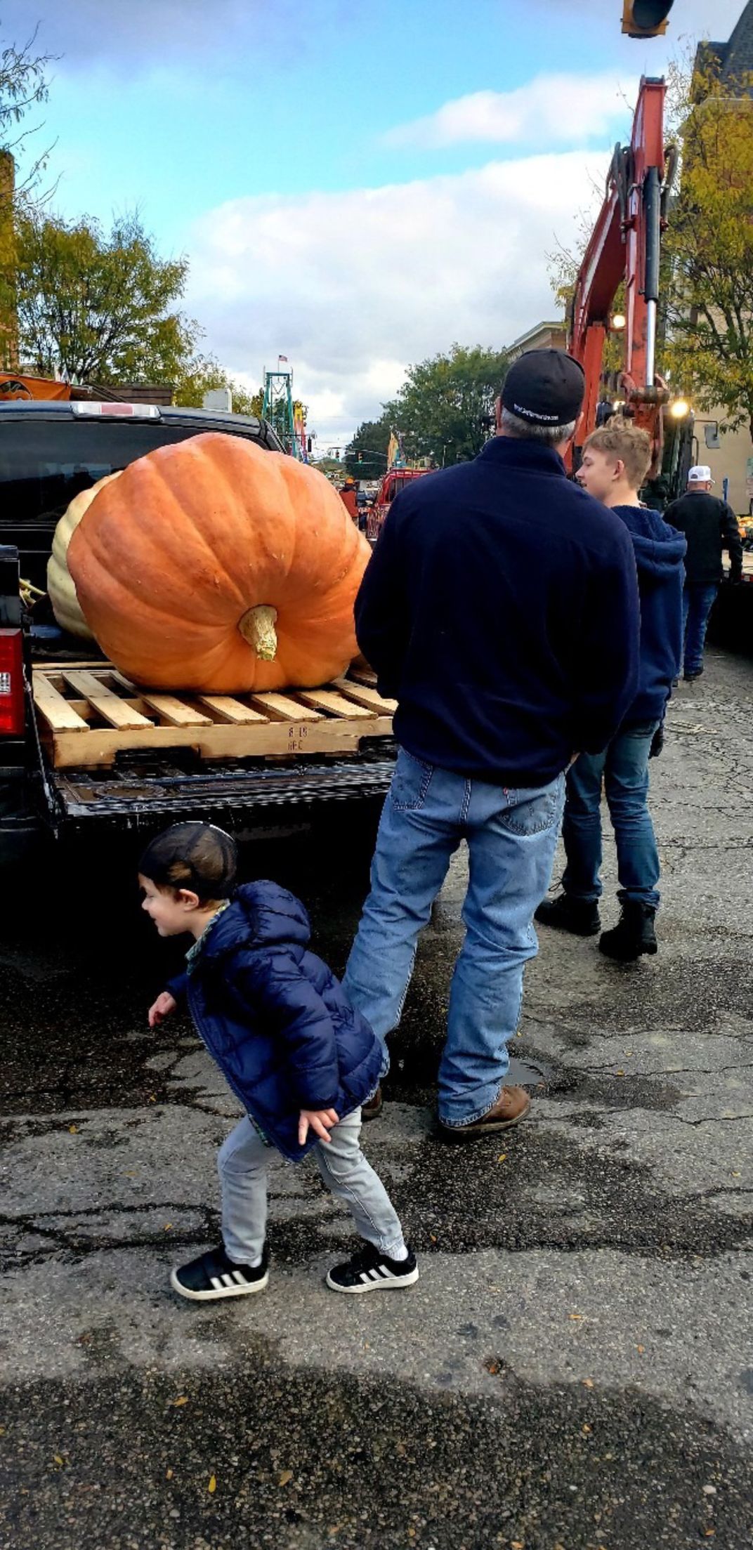Young Boone Ritchie running by his papaw Tim Ritchie's giant pumpkin at ...