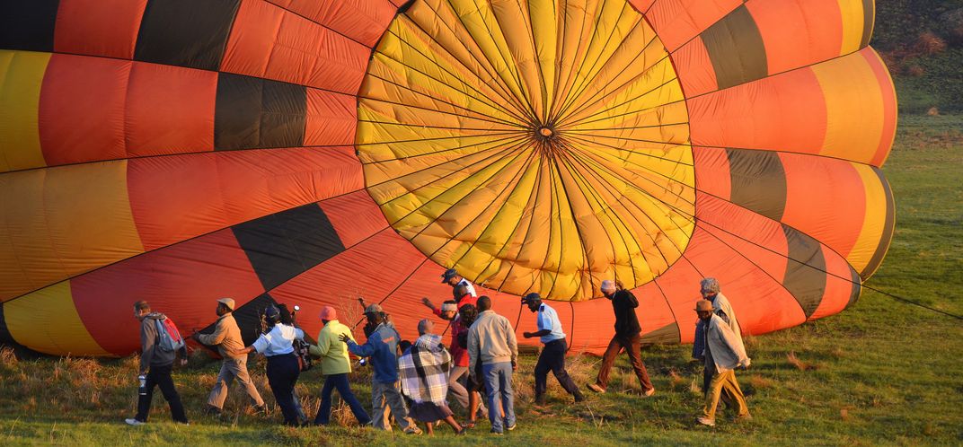 People: People walking next to deflated hot air balloon early in the ...