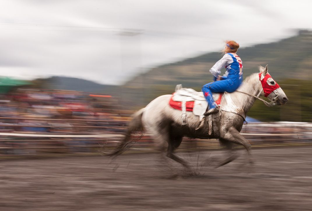 Female stunt rider going backwards on a horse in the mud at a local ...