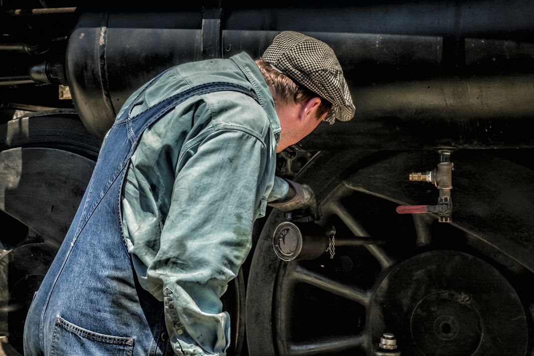 For the love of trains, a steam engine worker checks the old girl. This ...