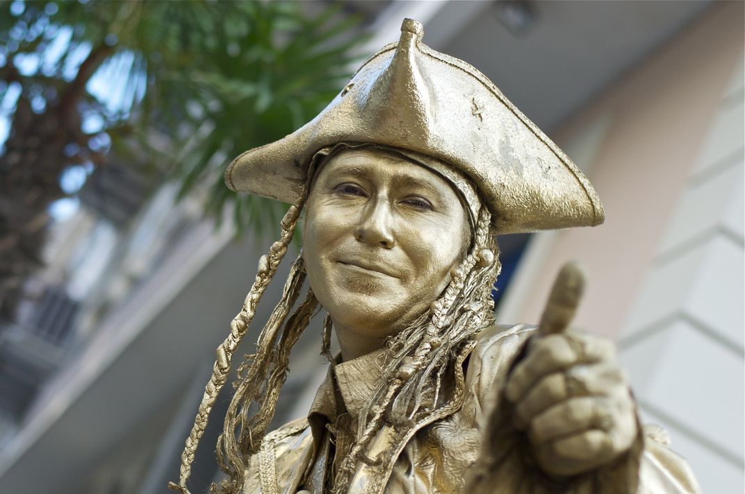 A street entertainer dressed as a pirate delighting the tourists on the ...