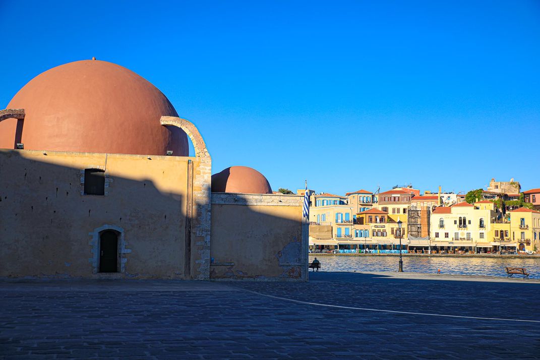 A shadow across the red dome Greek church and Chania old town and bay ...