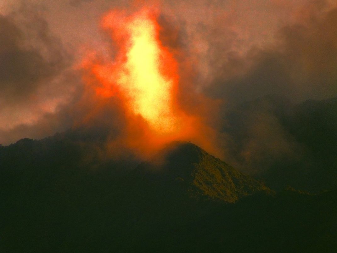 A mountain with a unique cloud shape made for an erupting volcano ...