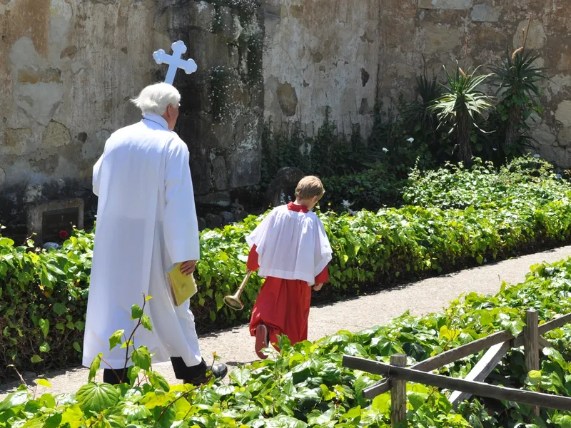 A Priest and Alter Boy make their way through the courtyard at the ...