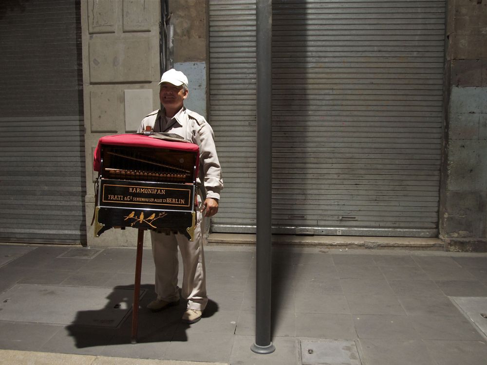 In the busiest street of downtown Mexico City, a "Cilindrero" with a ...