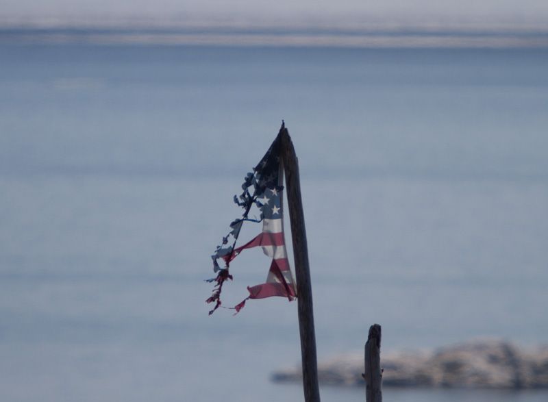 Tattered flag overlooking the ice covered Bering Sea in Nome, Alaska ...