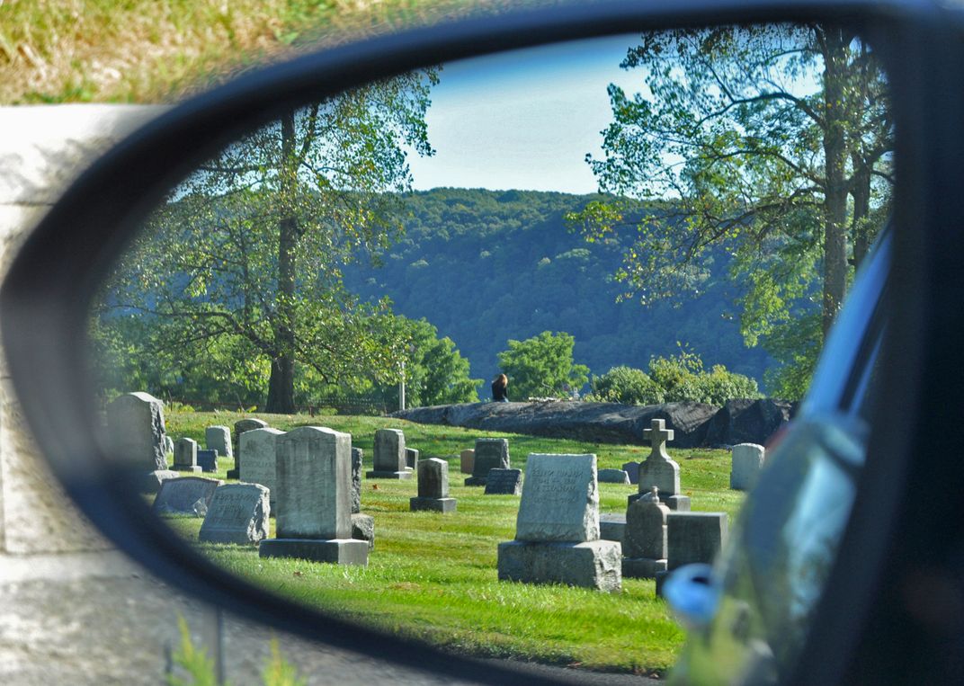 A person in a cemetery mourning the loss of a loved one observed in a ...