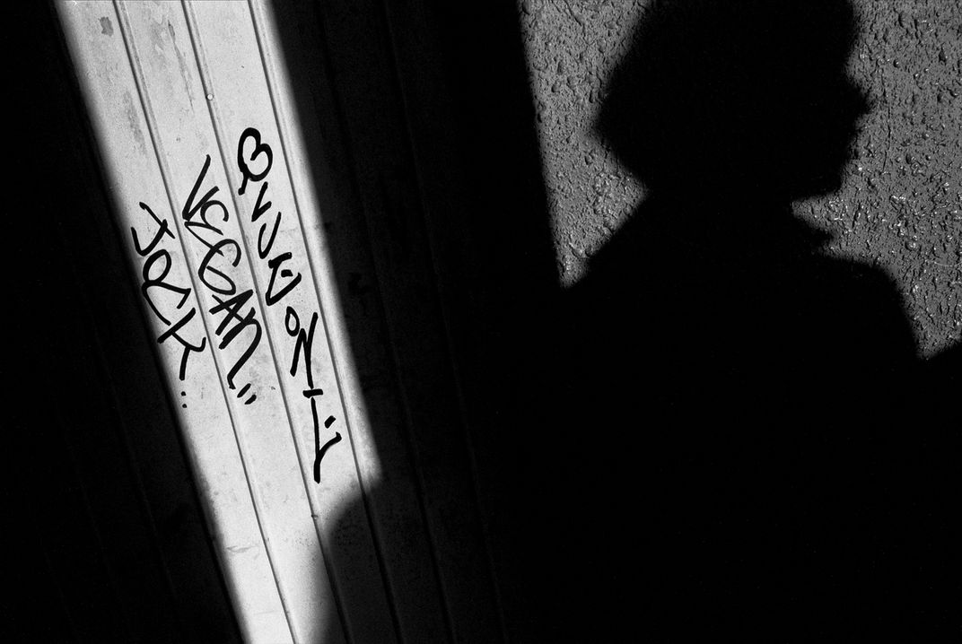 Shadow of a pedestrian is casted on a wall of a back alley in Kyoto ...