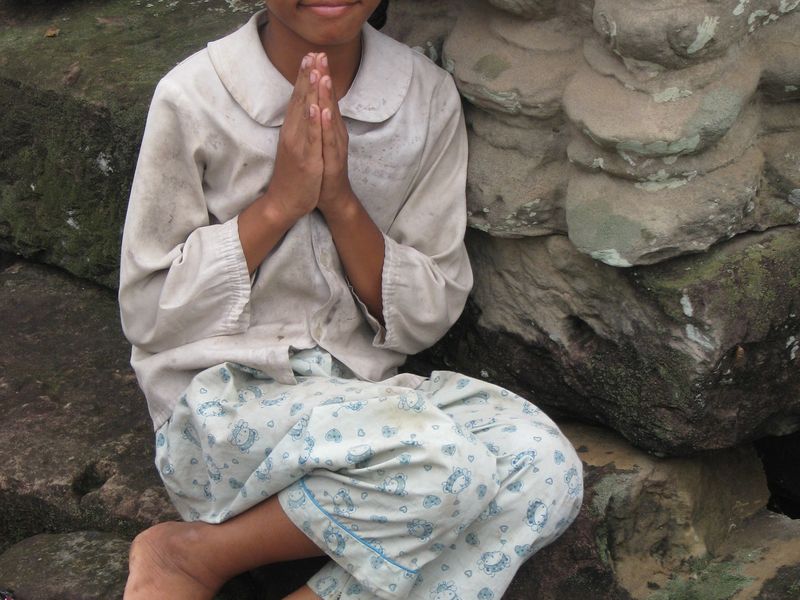 Street girl giving a sompiah greeting in Siem Reap, Cambodia ...