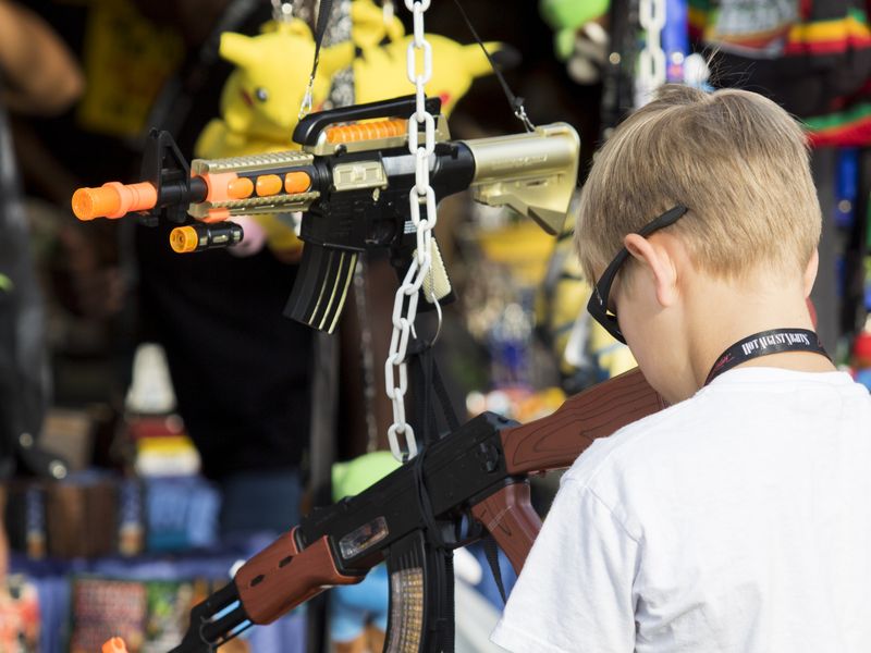 A child looking at a selection of toy guns | Smithsonian Photo Contest ...