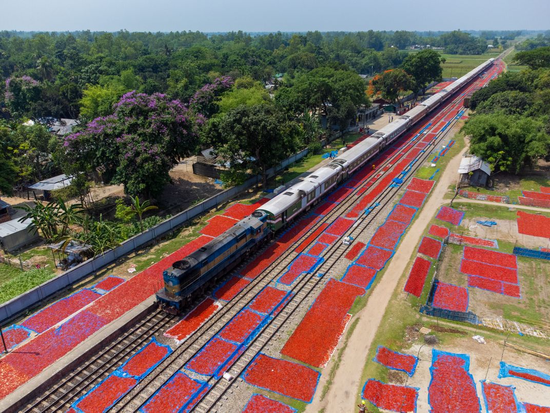 A passenger train is speeding along the red carpet of rails ...