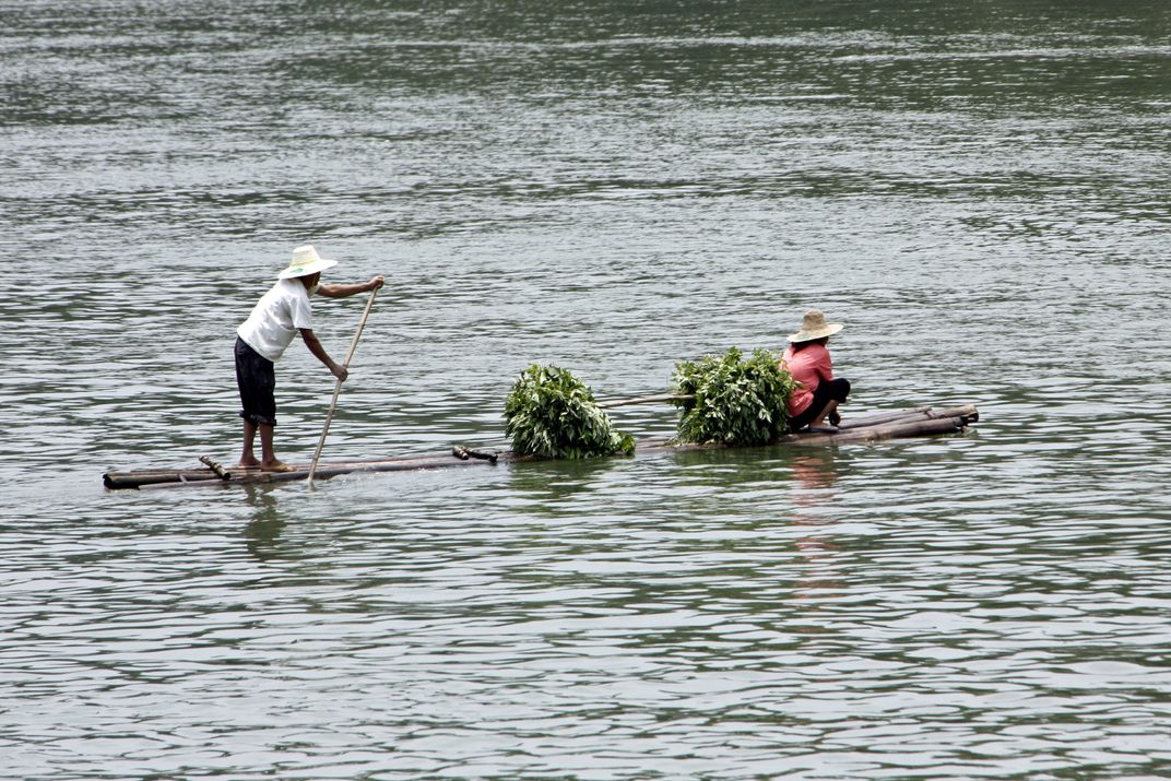 Chinese women paddling a traditional boat across the Li River to take a ...
