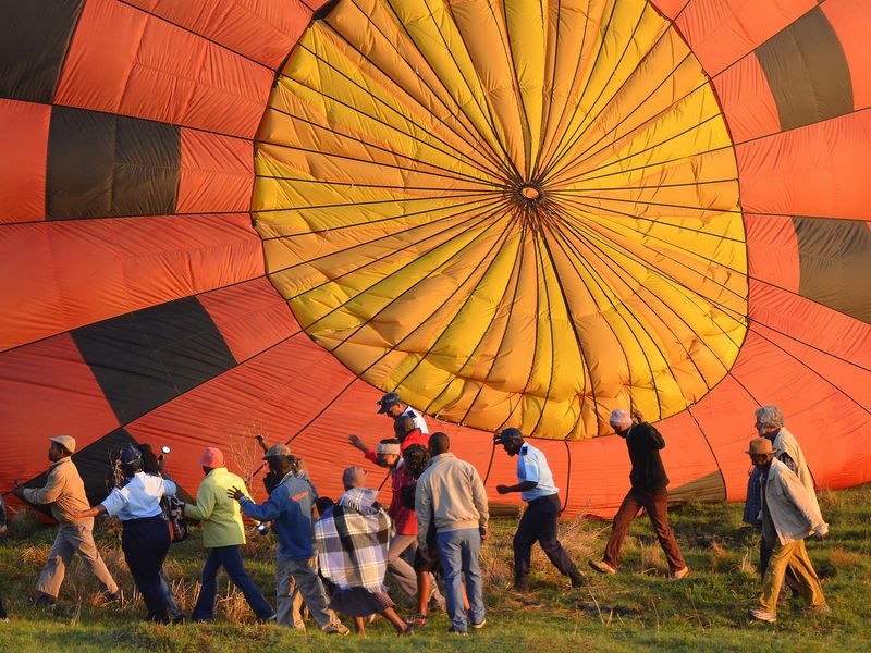 People: People walking next to deflated hot air balloon early in the ...