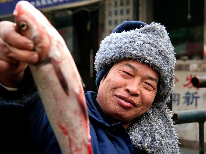 A man offers a fresh fish in Zibo, China. | Smithsonian Photo Contest ...