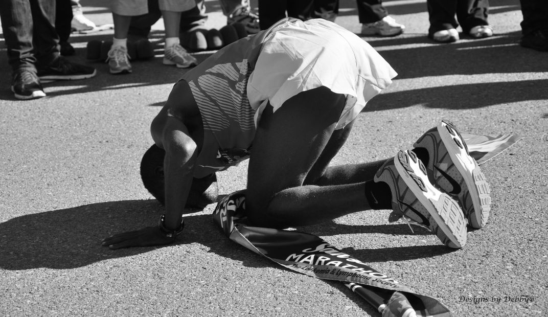 Runner Kneeling in Thankfulness for Winning First Place in a Marathon ...
