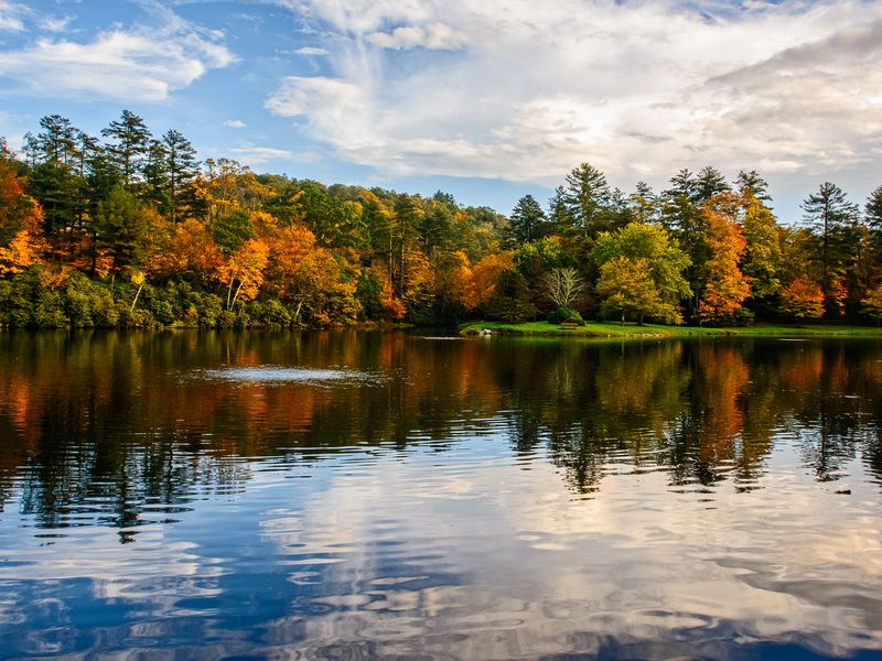 Clouds reflected in pond with fall colors in background | Smithsonian ...