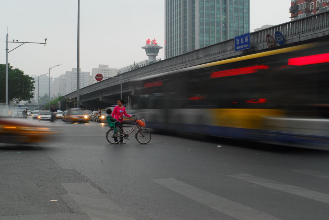 Woman and young child on bicycle in the middle of an intersection with ...
