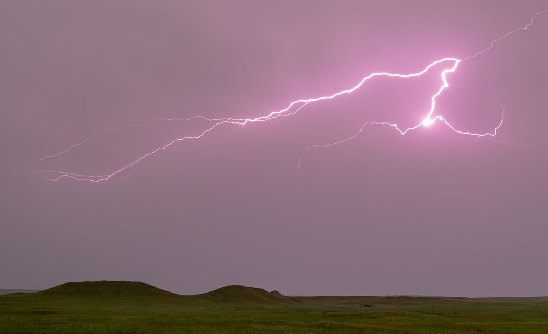 A bolt of lightning from a summer thunderstorm flashes over the ...