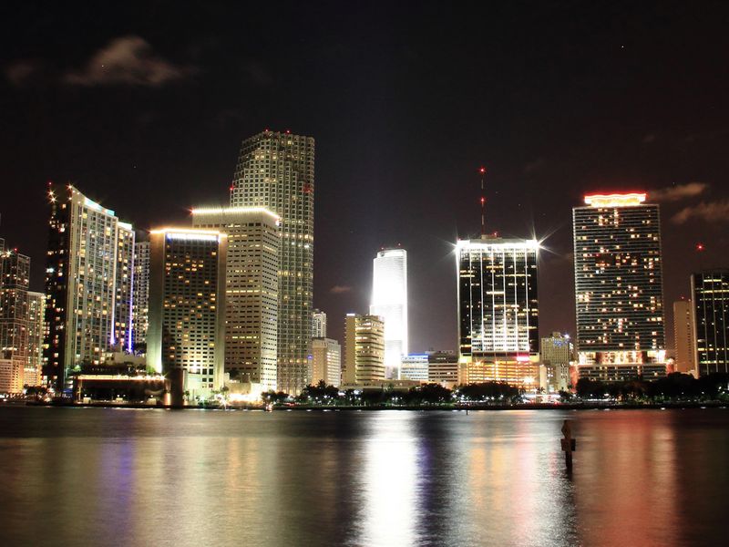 I love the skyline of Miami at night. This one building is lit up ...
