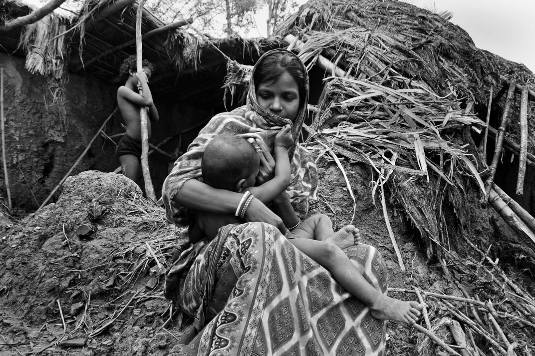 A mother feeding her baby when cyclone Aila is over at Sundarban ...