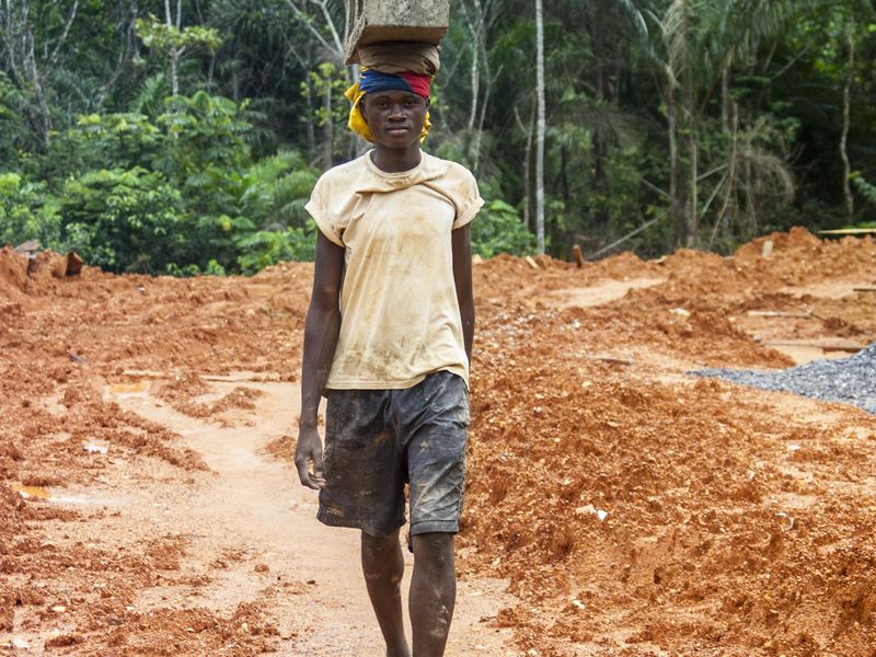 A boy carrying bricks in a construction site | Smithsonian Photo ...