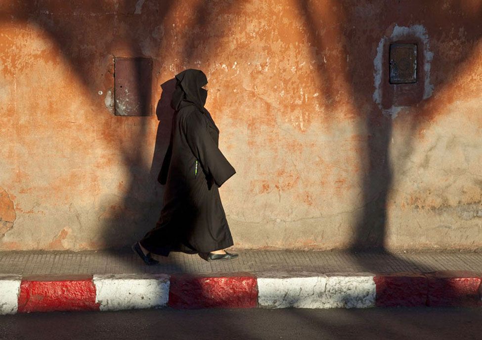 Women emerging from shadows outside Medina in Marrakesh, Morocco ...