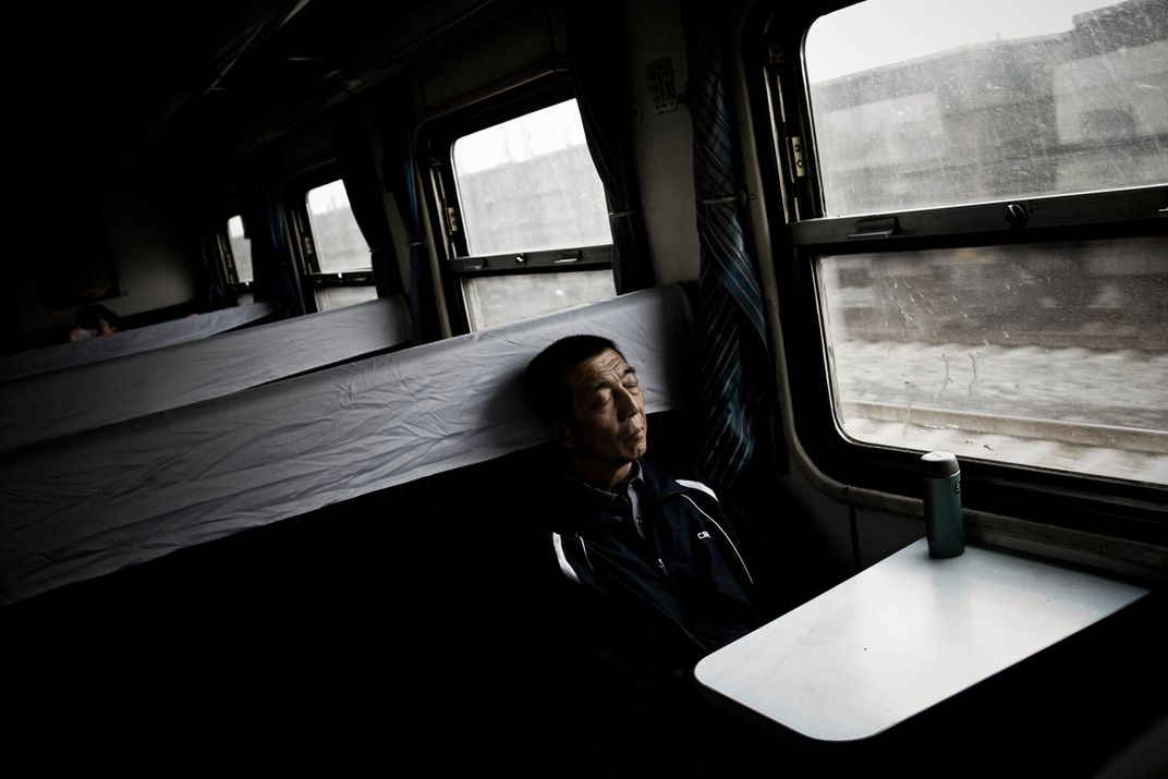 A man sleeping on the train that connects the cities of Datong and Ping ...