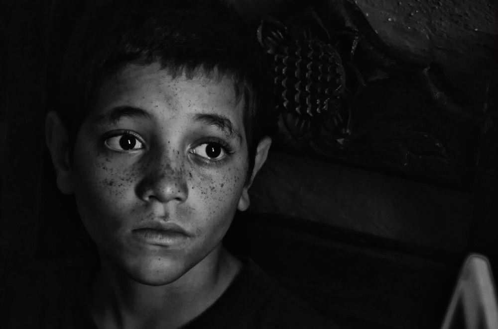 A child looks out the door of his house, looking for something ...