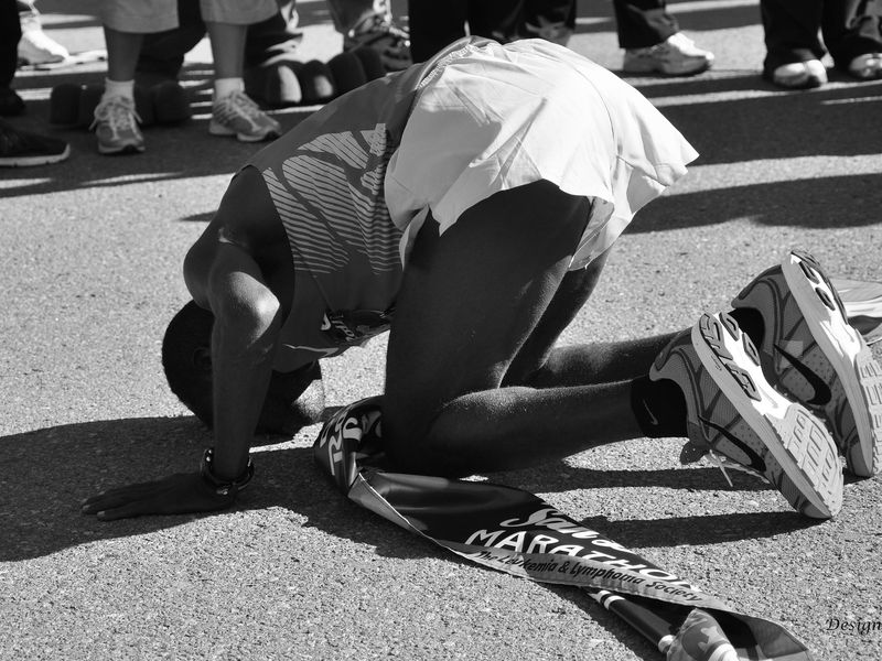 Runner Kneeling in Thankfulness for Winning First Place in a Marathon ...