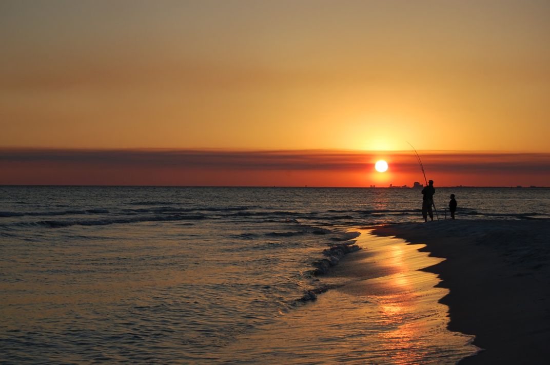 Catching a sunset while a man and his son catch fish. | Smithsonian ...