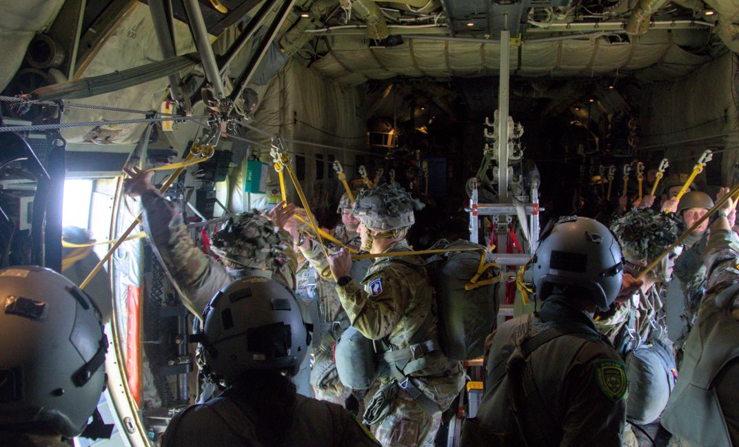 Paratroopers jumping out of a USAF C-130 overhead Normandy (France ...