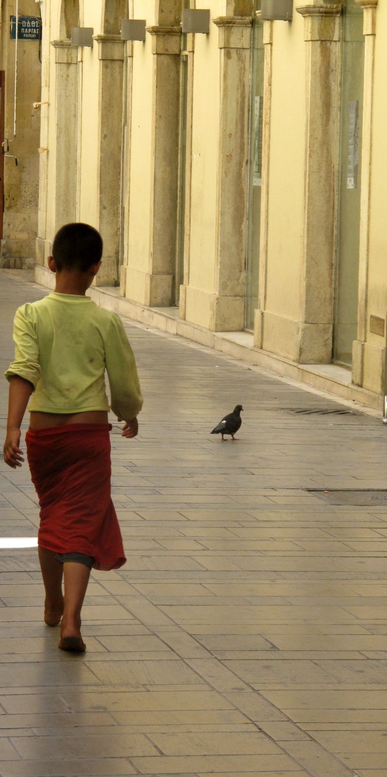 A gypsy boy walking on the cobbled streets of the island Corfu in ...