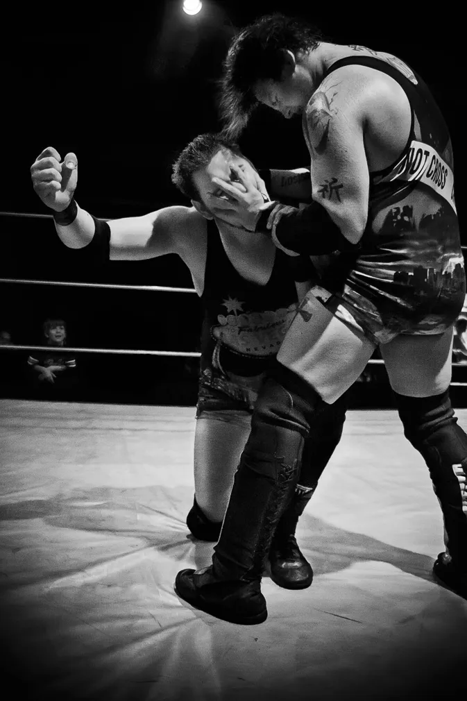 Wrestler, Chrisifix Lostson does a death grip on Ross Vegas, as a young ...