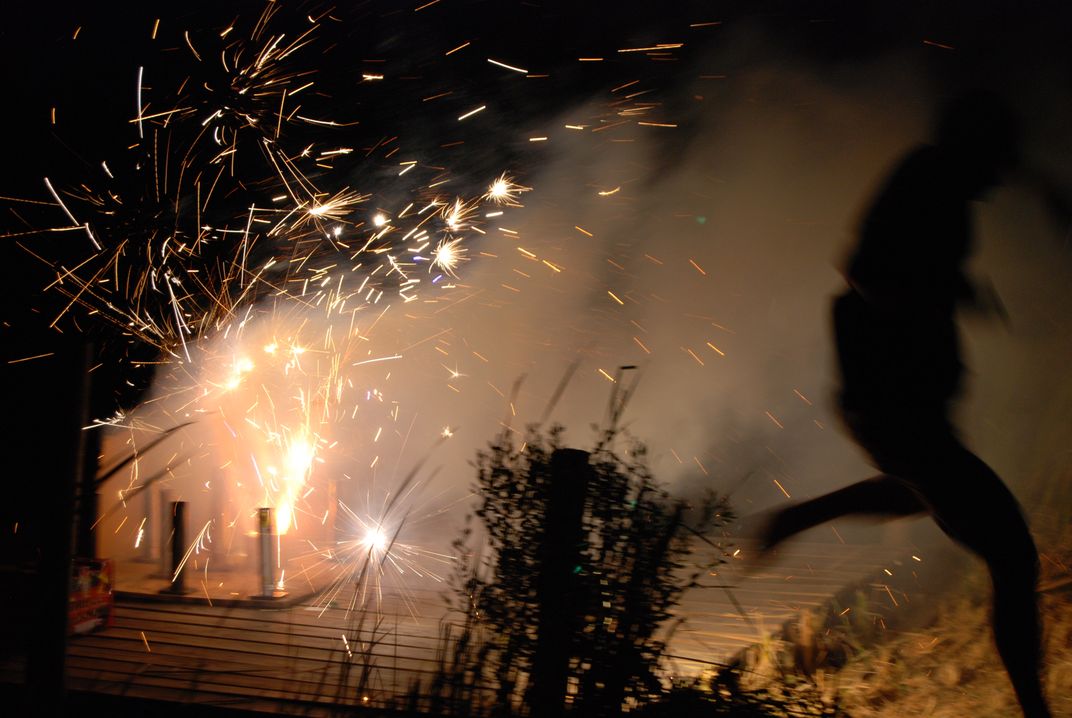 A man jumping out of the way after setting off some fireworks for the ...