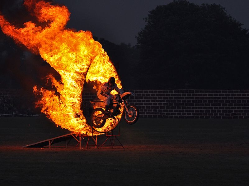 A stunt-man is jumping through fire ring in a show. | Smithsonian Photo ...