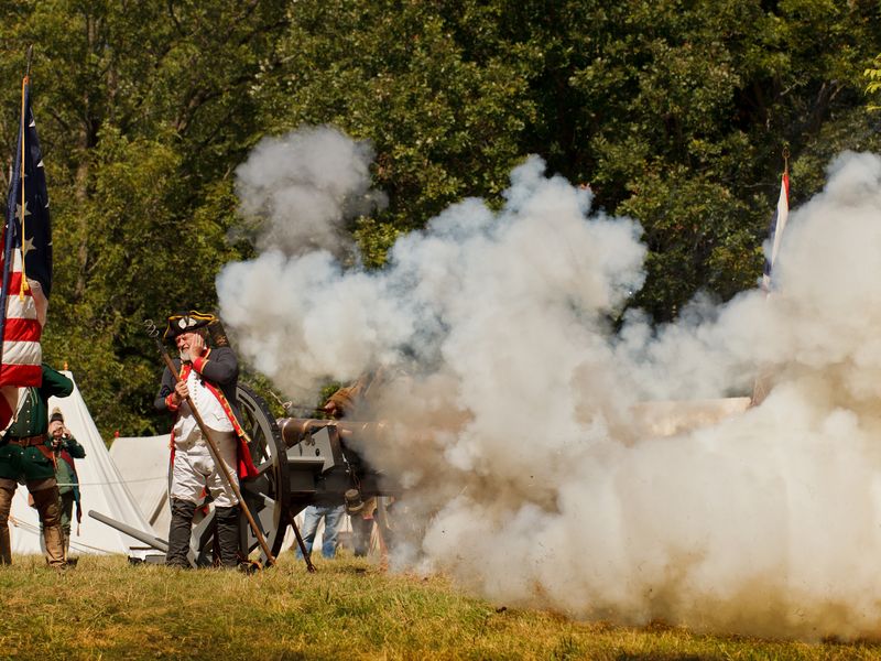 CANNON BLAST -- A re-enactor protects his hearing from the blast of a ...