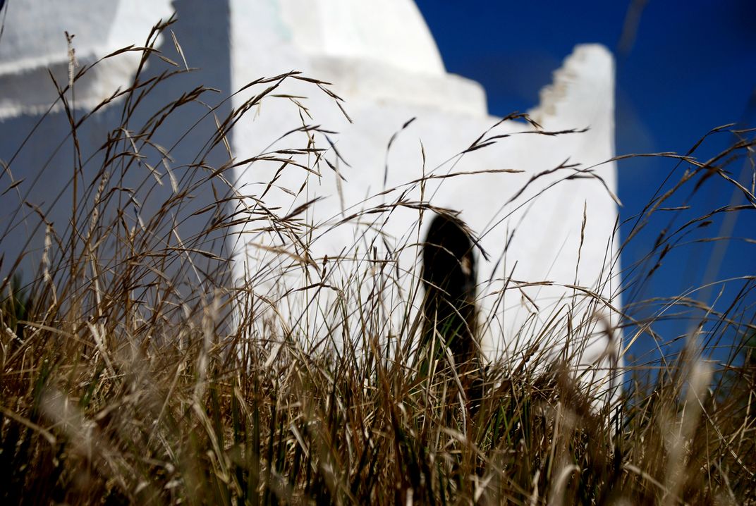 A shot of a marabout tomb through some grasses. A Marabout is an ...
