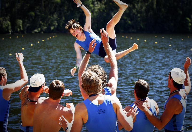 Members of a winning rowing team throw one of their own into the water ...