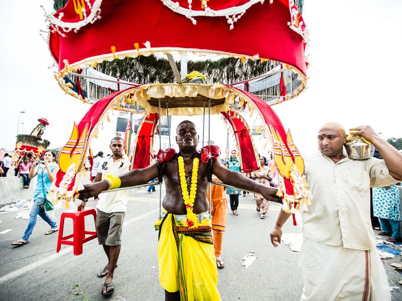 A Hindu devotee carries a Kavadi towards the Batu Caves in Kuala Lumpur ...
