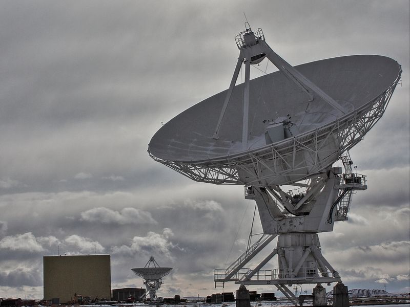 A back-lit satellite - one of many at the NRAO Very Large Array ...