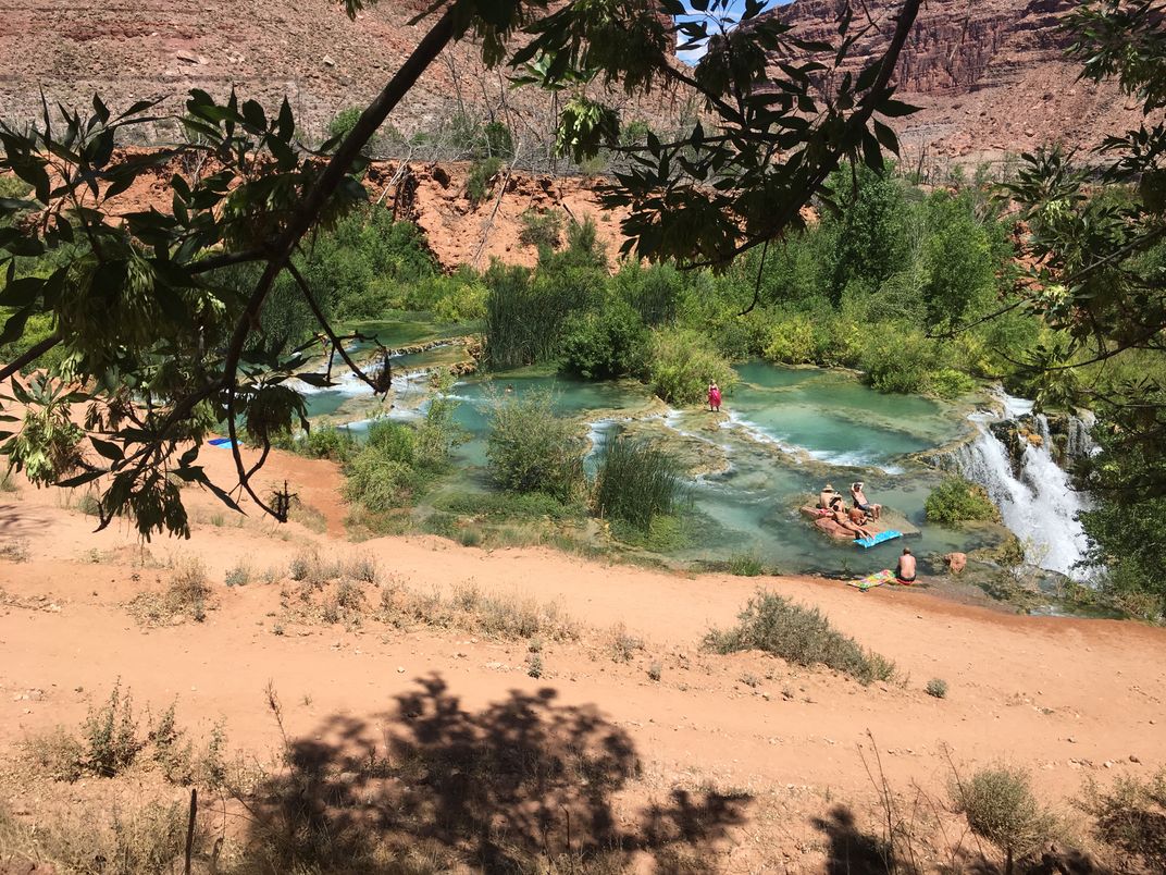 People lounging near a water fall at Havasupai Indian Reservation ...
