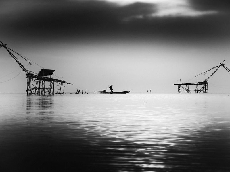 The fisherman balancing his body while preparing to start the fishing ...