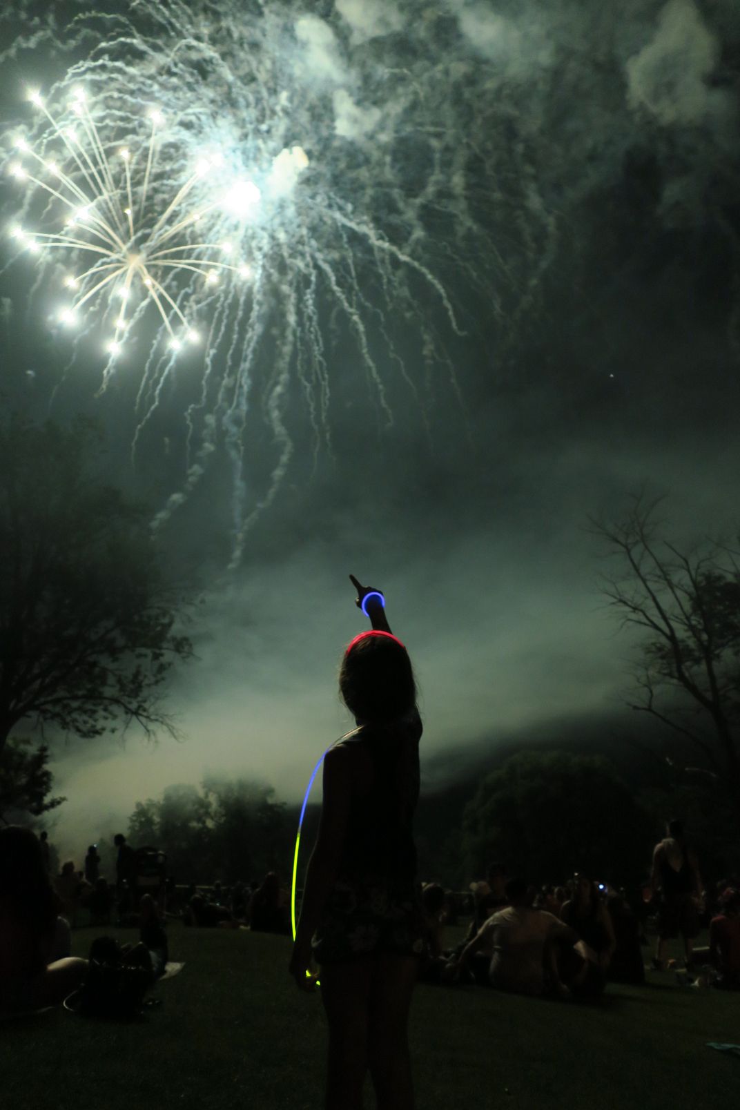 My little girl lit up with glow sticks pointing to the fireworks in the ...