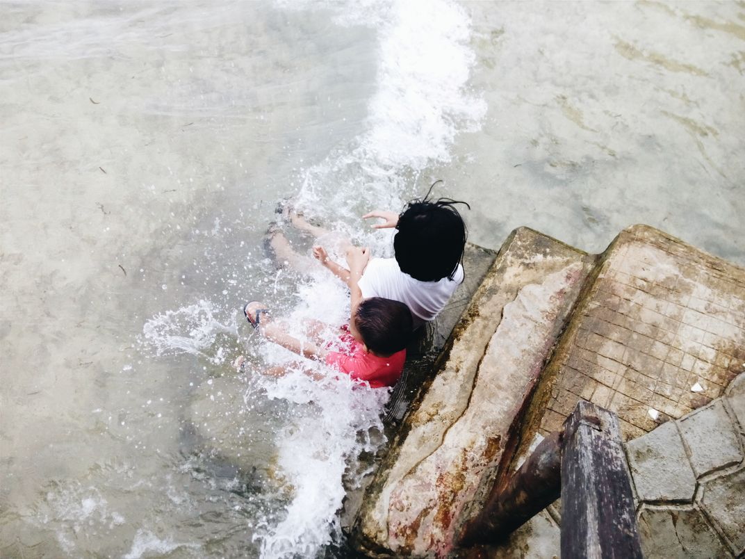 Innocent kids by the beach enjoying the waves | Smithsonian Photo ...