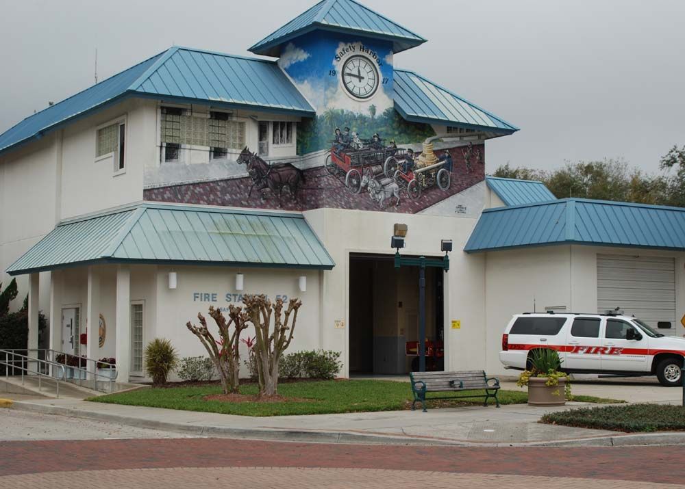 a modern firehouse and vehicle with a mural depicting the old way ...