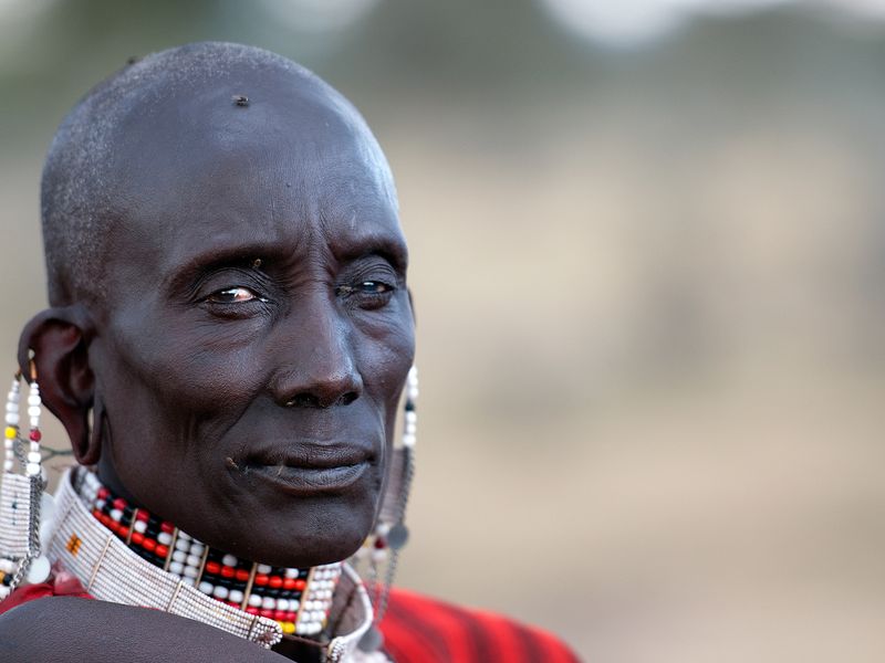 A Masai woman keeps a watchful eye on the Manyata ceremony taking place ...