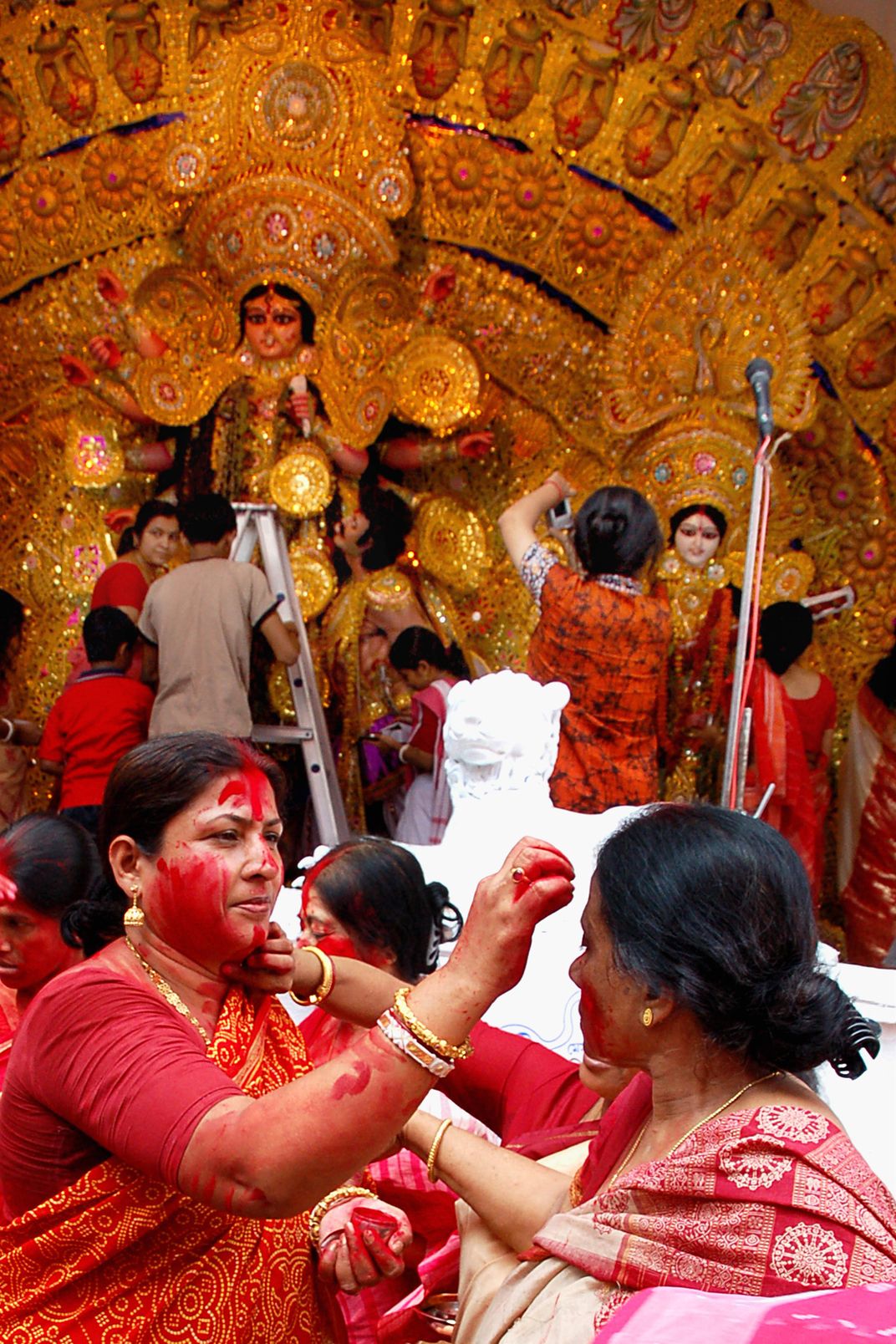 Women devoties spreading Sindur on the others fore head as a ritual ...